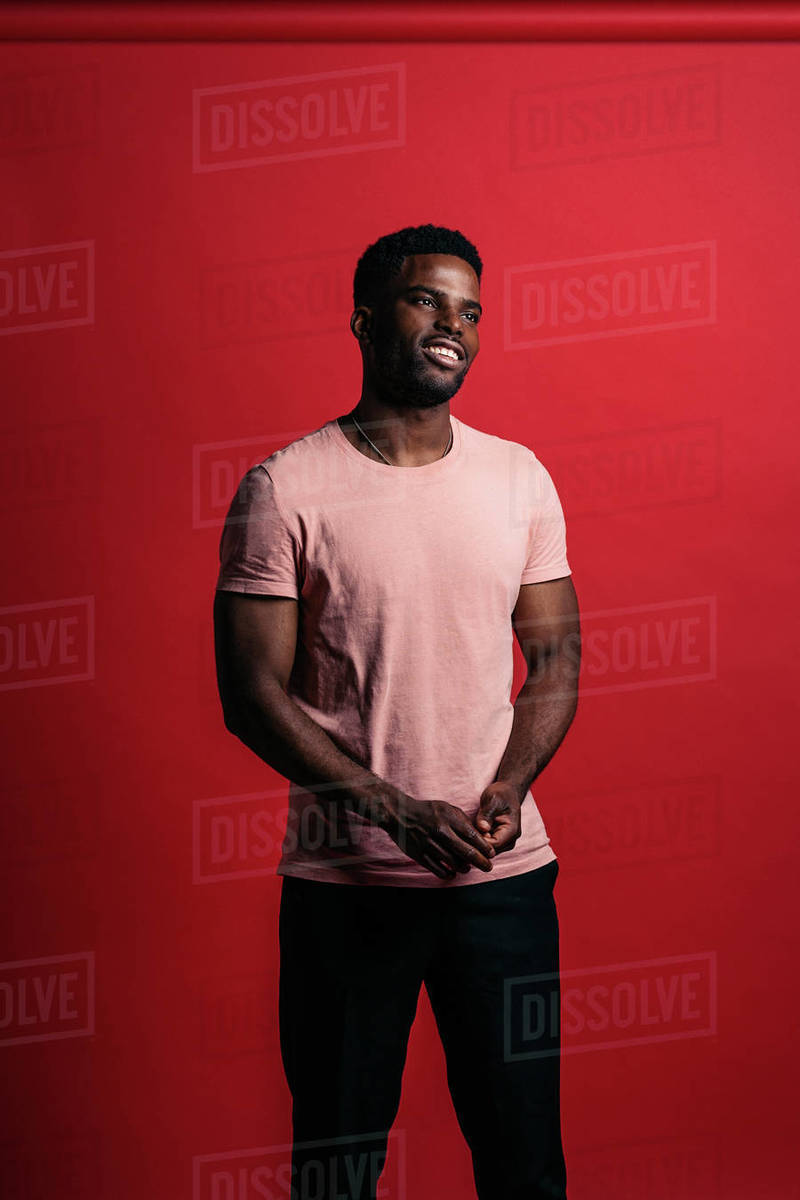 Portrait of young african man on bright red background - Stock Photo ...