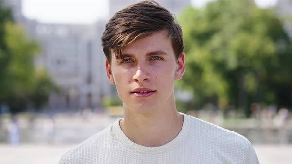 Attractive man with moles on face wearing t-shirt looking at camera ...