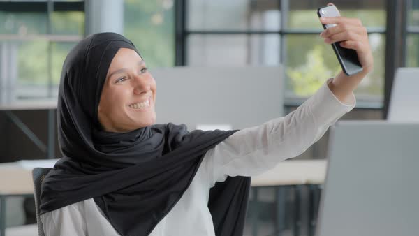 Positive young muslim woman in hijab office worker blogger photographed ...