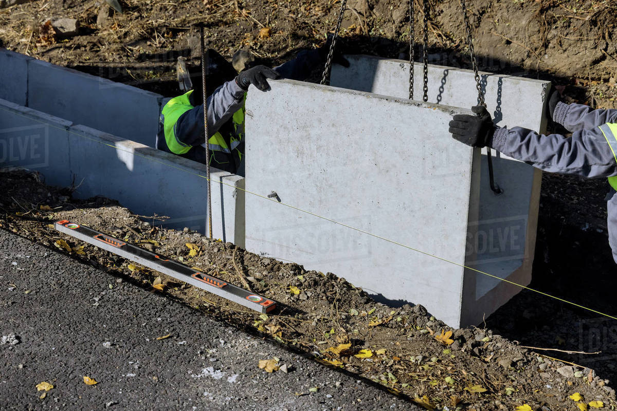 Road worker mounting U-ditch, U-shaped water channel construction the ...