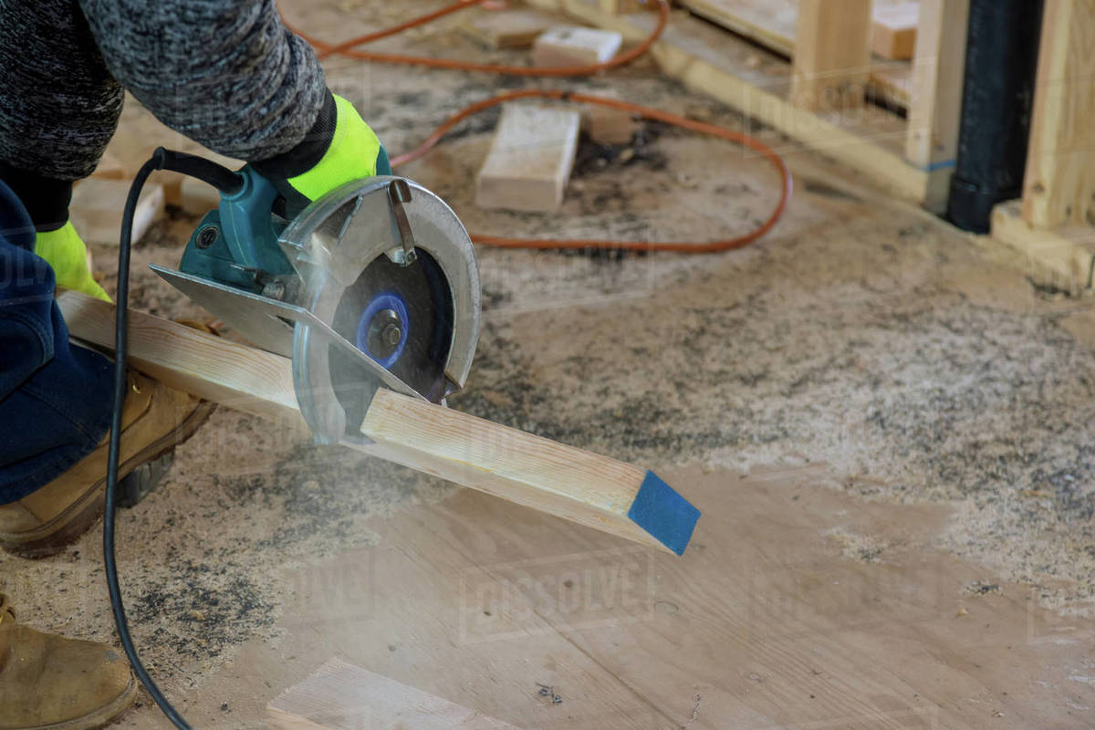 Carpenter using circular saw for wood beam a new home constructiion ...