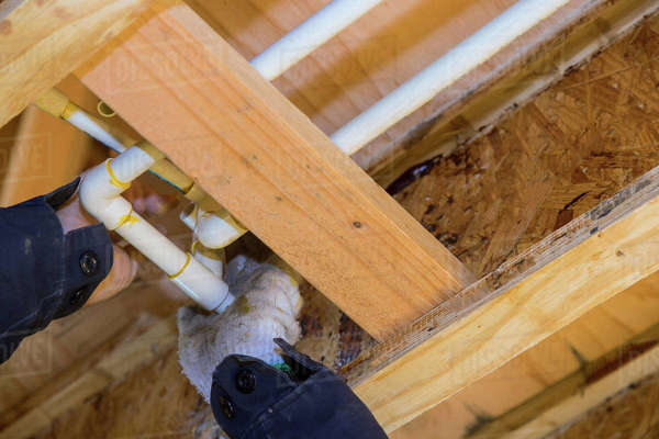 The worker is using a glue PVC pipe for installing the water pipe in ...