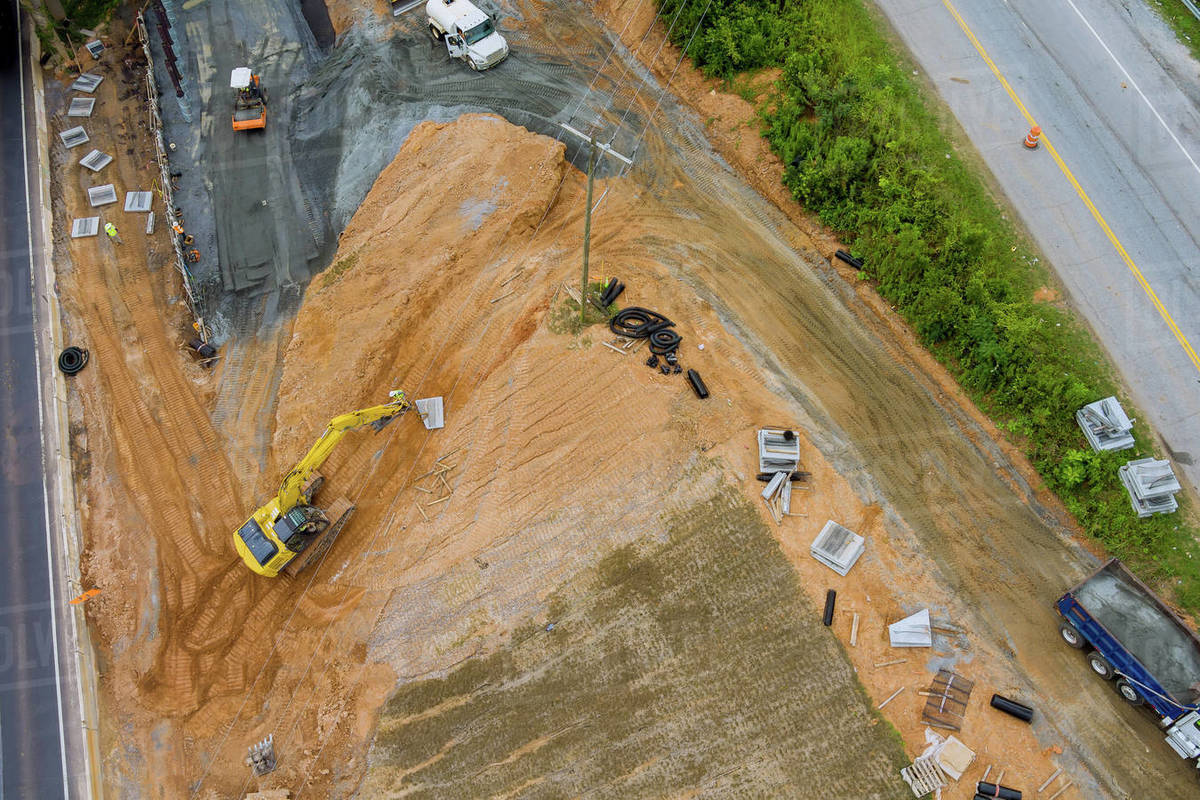 Aerial view construction of road interchange workers heavy machinery ...