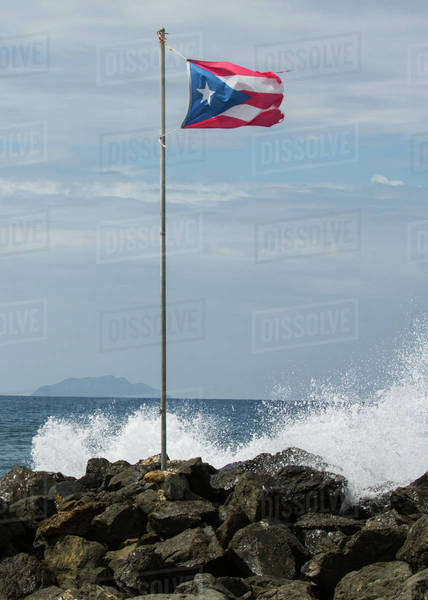 Puerto Rican flag waving in front of ocean - Stock Photo - Dissolve