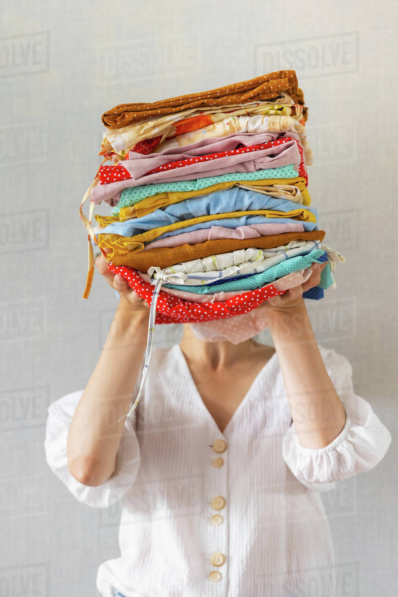 Women's hands hold a large stack of colorful underwear or clothes ...