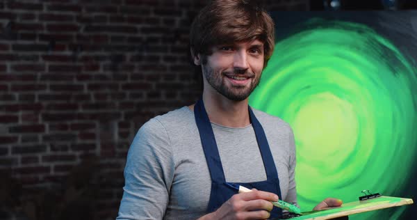 Portrait of handsome Talented Artist is smiling to the Camera, standing ...