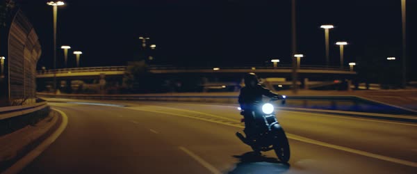 TRACKING Shot of a biker riding his custom built cafe racer motorcycle ...