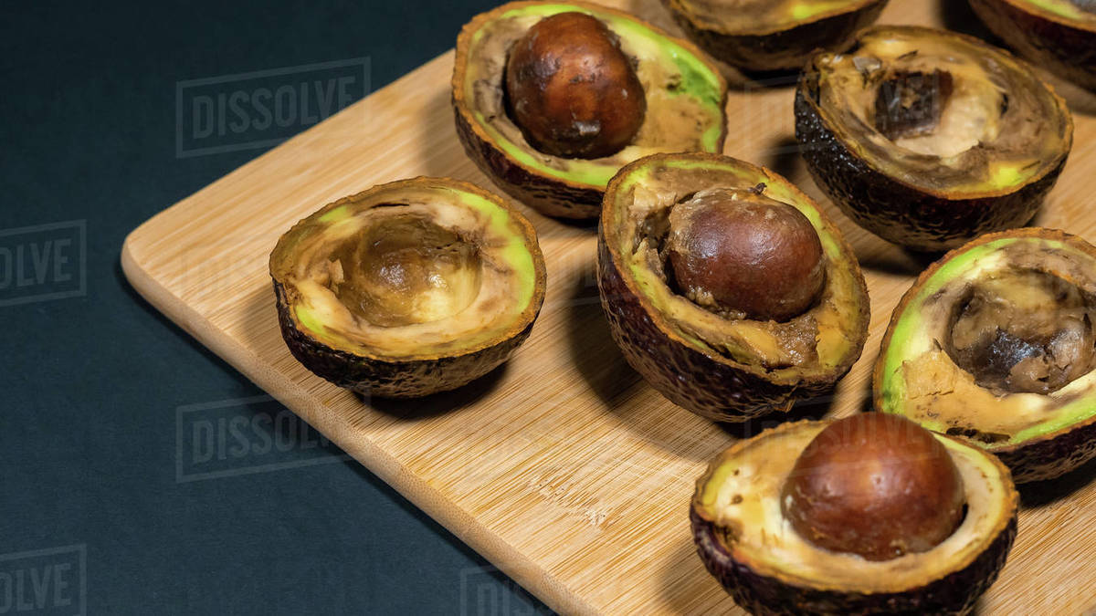 Rotten Avocados Halfs on table. Bad Fruits on wood Chipper. Overripe ...