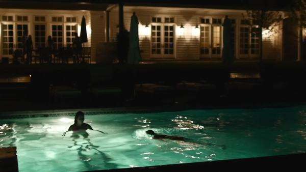 2 teenage friends practice handstands underwater in a swimming pool ...