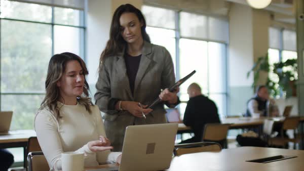 Young Professional Looks Over A Colleague's Work On Laptop, Happy To ...