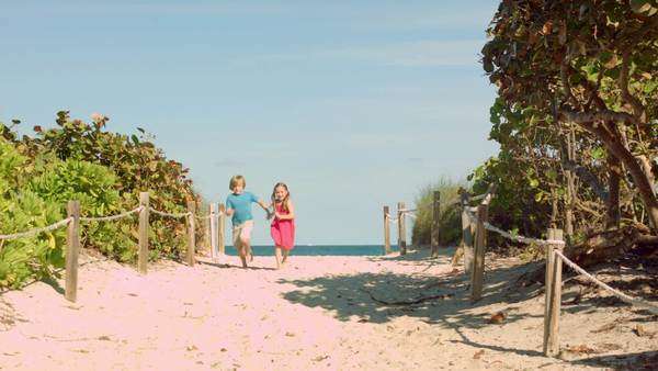 Little Kids Hold Hands And Run Down Beach Path Toward Camera And Smile ...