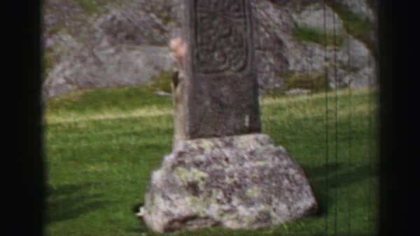 1952: Stoic cross stands tall in a rocky grassland among few passerby's ...