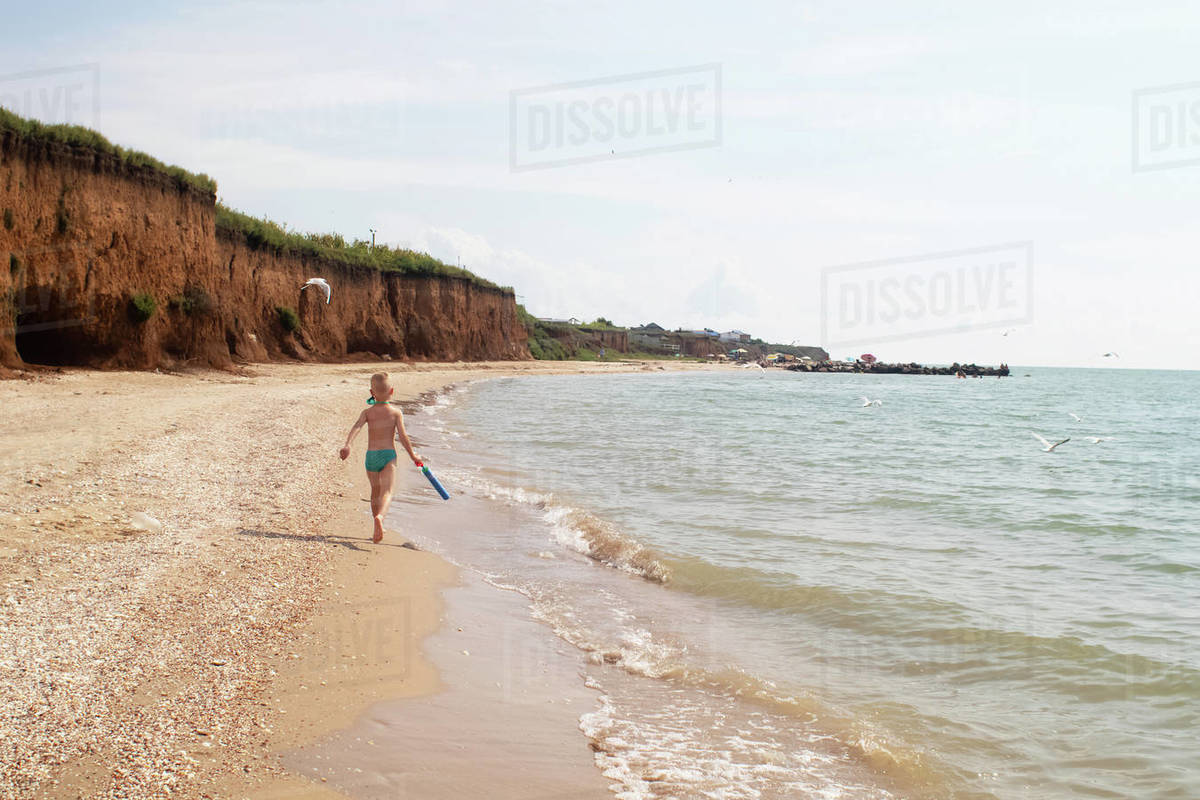 Child on the sandy beach. Happy life and relaxation by the ocean ...