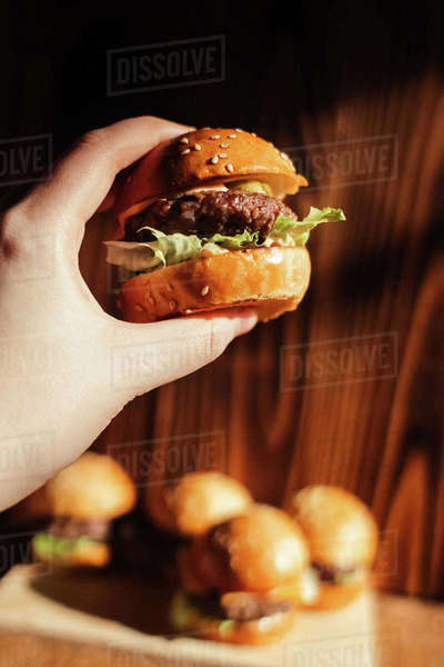 Mini burger on a stand close-up. Children fast food in a restaurant or ...
