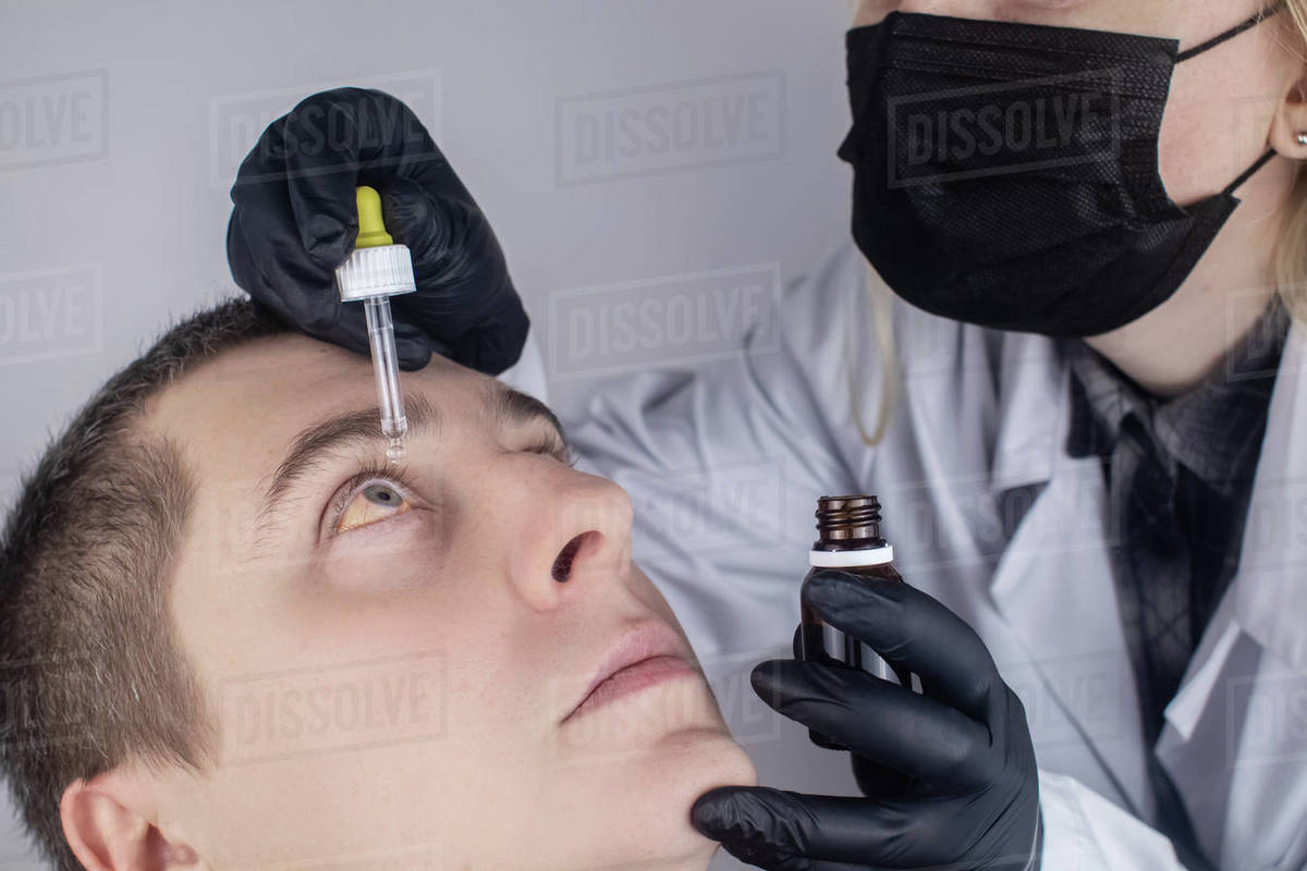 Close-up of eye drops. A man at the doctor appointment who drips eye ...