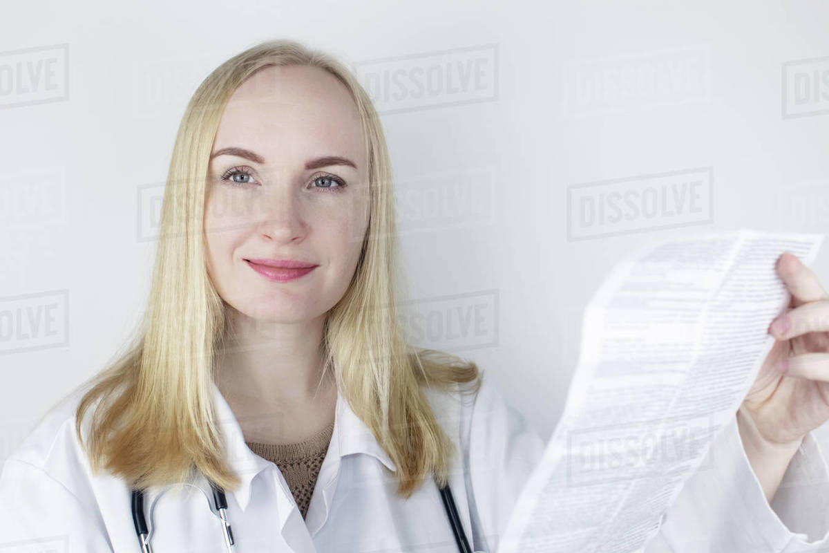 The doctor on a white background reads the instructions for medicines ...