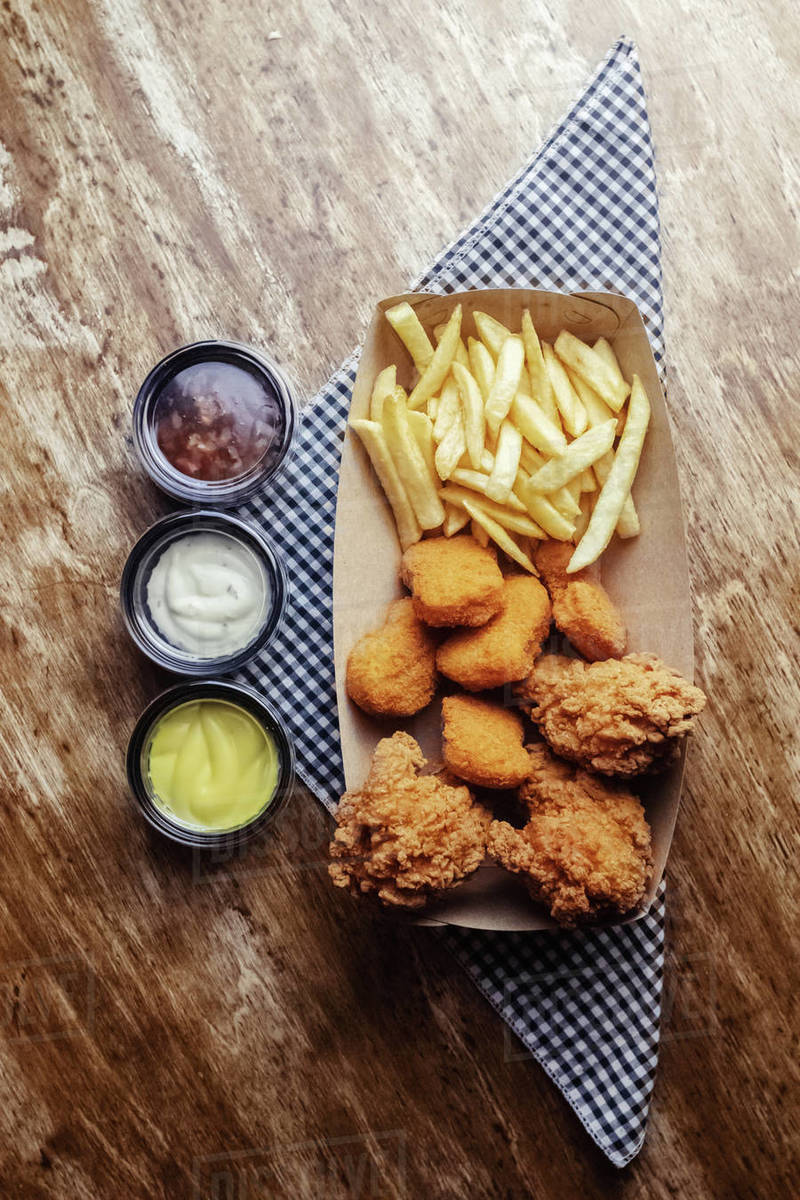 Top view of chicken nuggets, batter wings and fries. A set of three ...
