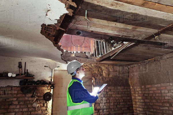 Building inspector. Man in a hard hat and a yellow reflective vest ...