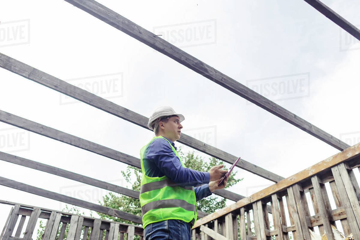 Building inspector. Man in a hard hat and a yellow reflective vest ...