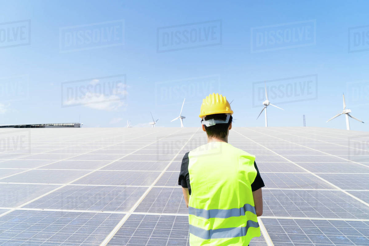 Alternative energy concept - engineer standing on solar panels, green ...