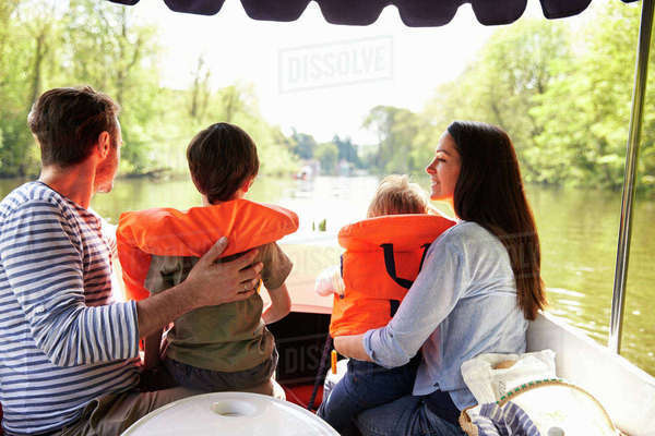 Family enjoying day out in boat on river together - Royalty-free Stock ...