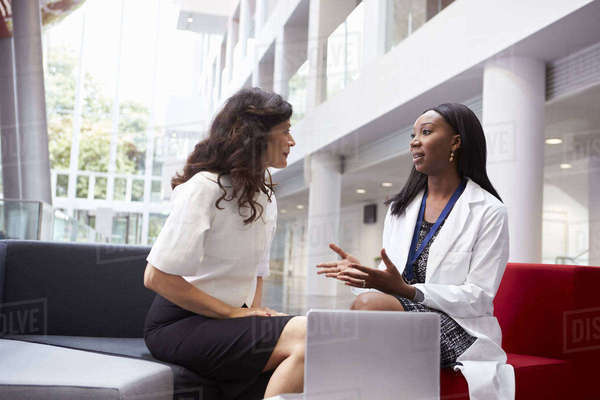 Doctor and patient having meeting in hospital reception area - Stock ...