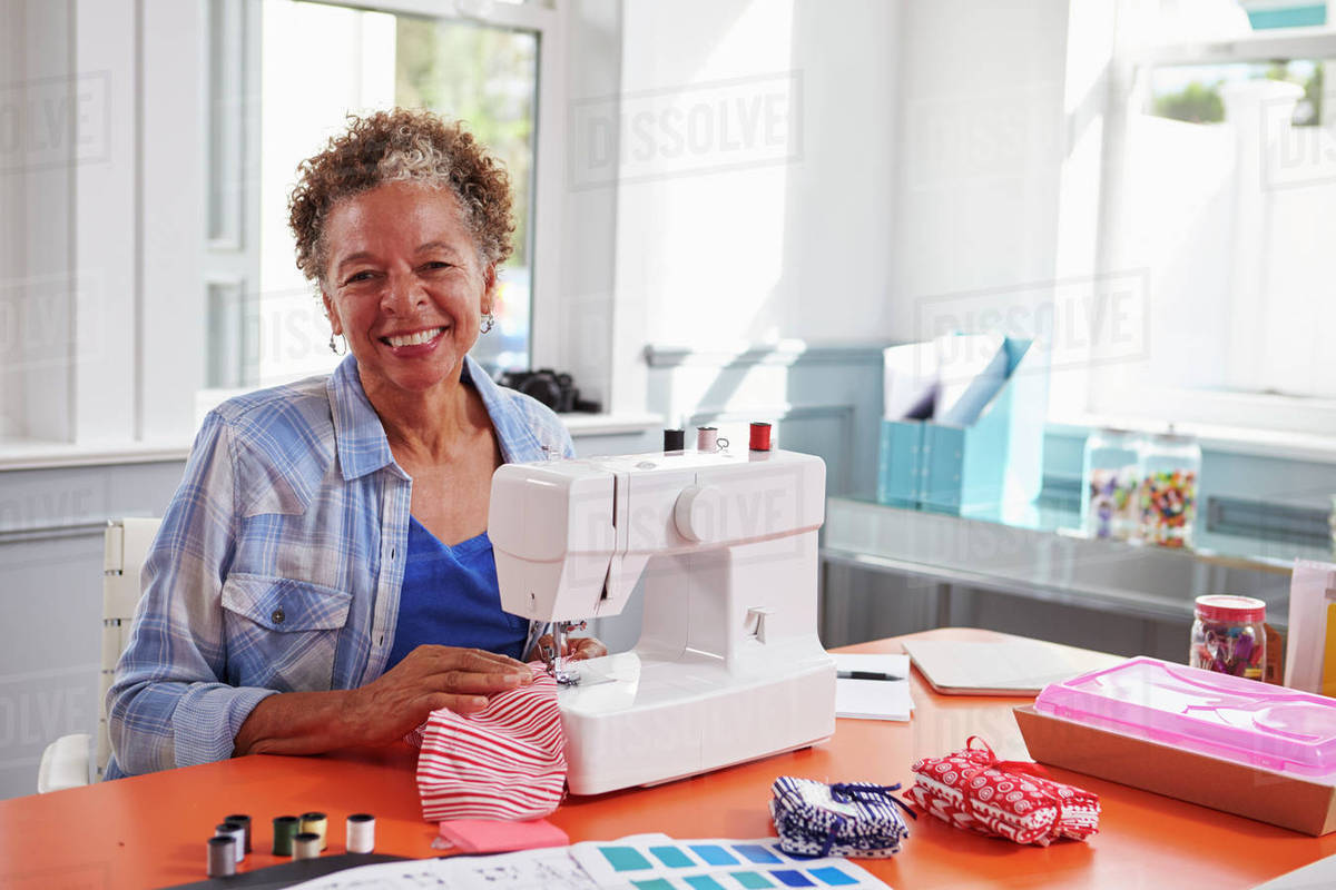 Senior black woman using a sewing machine looking to camera - Royalty ...