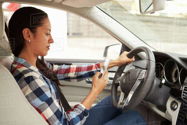 In car view of Hispanic female driver using phone - Royalty-free Stock ...