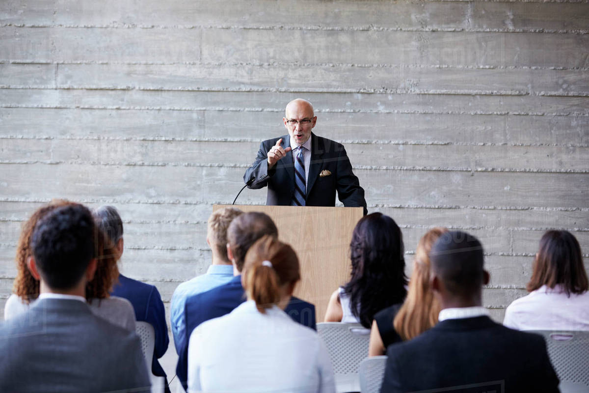 Senior businessman addressing delegates at conference - Stock Photo ...