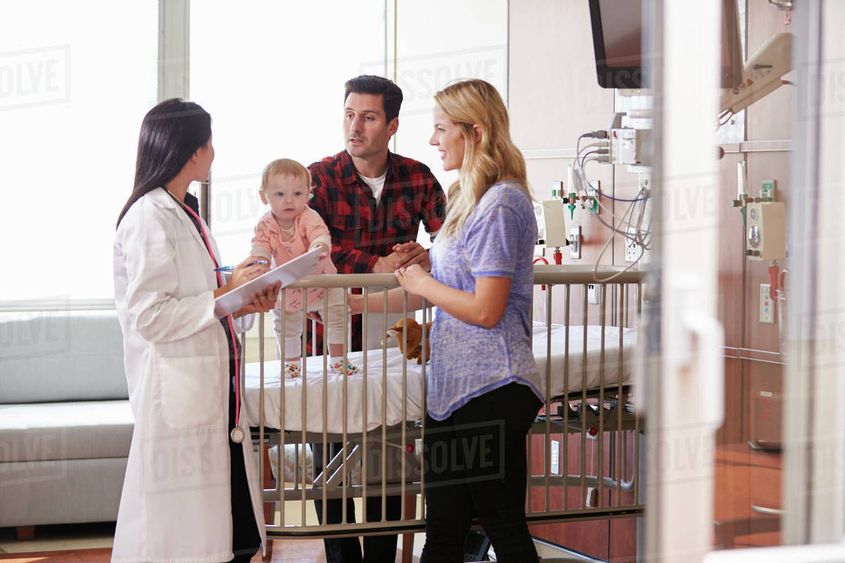 Pediatrician visiting parents and child in hospital bed - Royalty-free ...