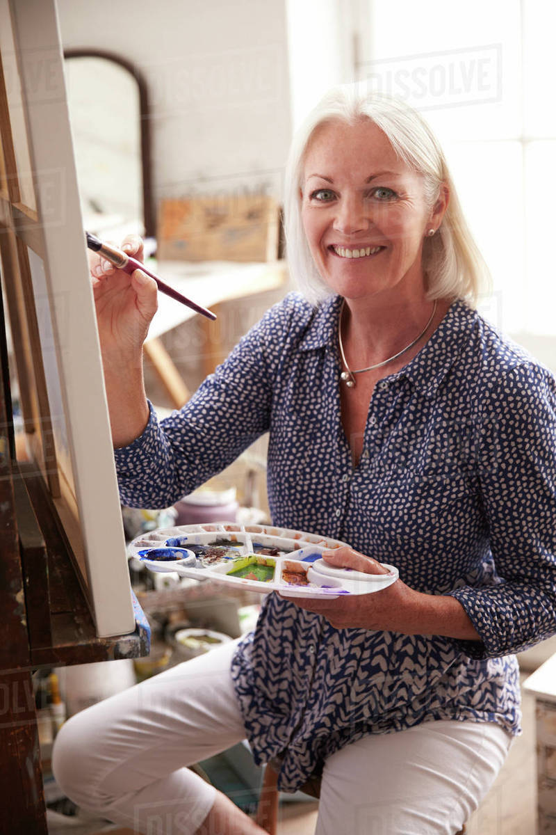 Portrait Of Female Artist Working On Painting In Studio - Stock Photo ...