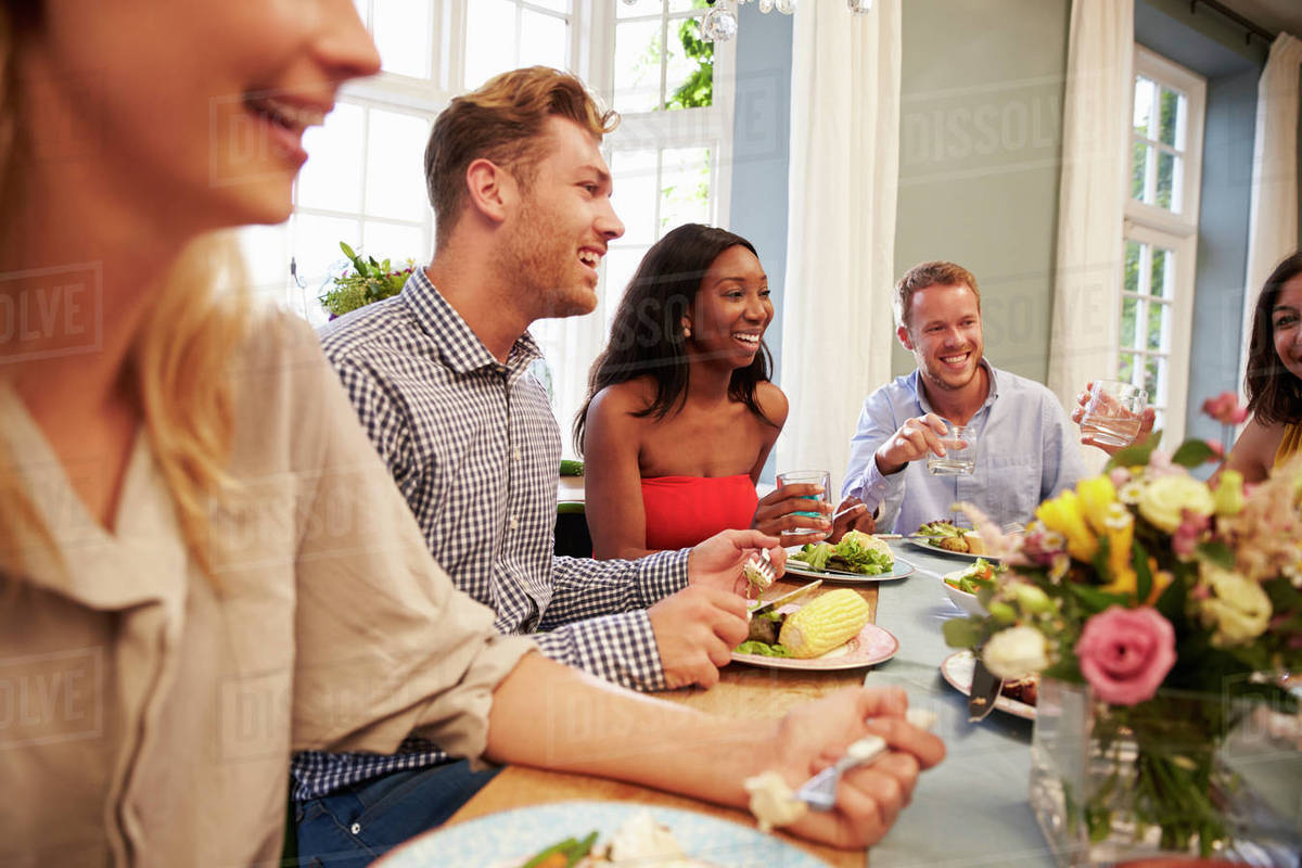 Friends At Home Sitting Around Table For Dinner Party - Royalty-free ...