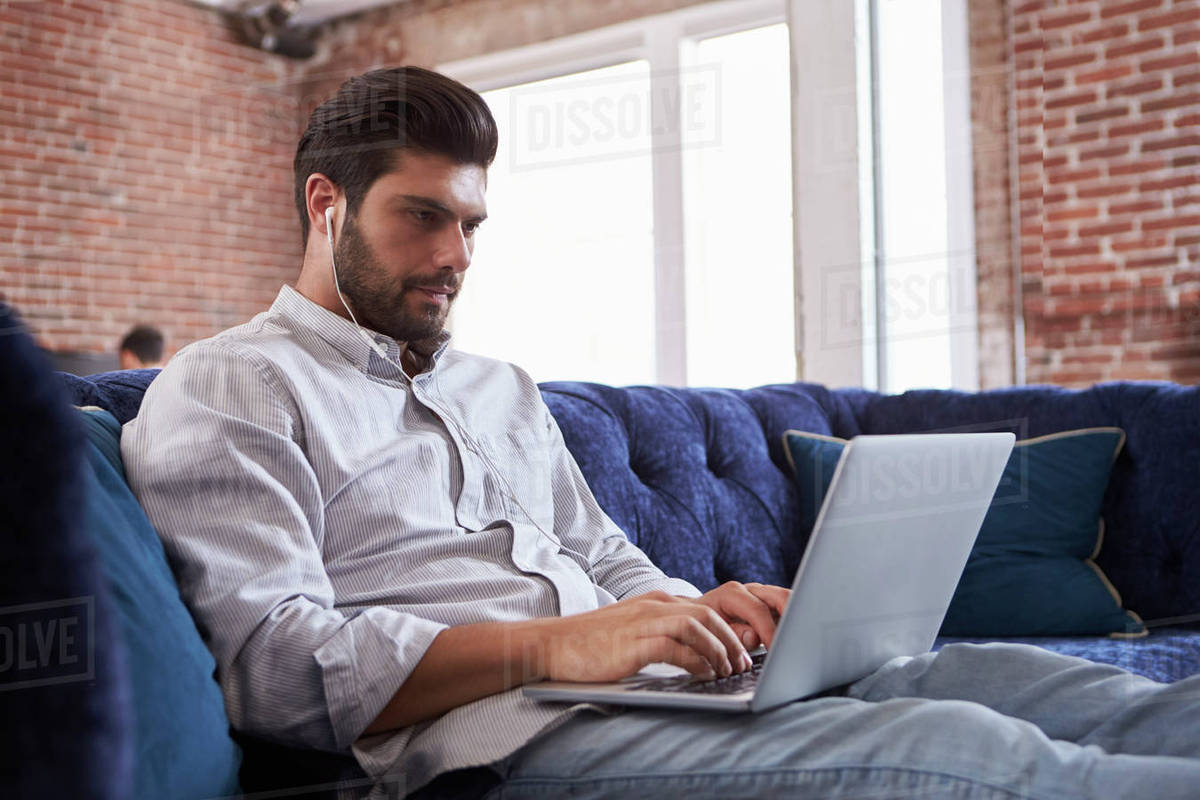 Businessman working on sofa in modern creative office - Royalty-free ...