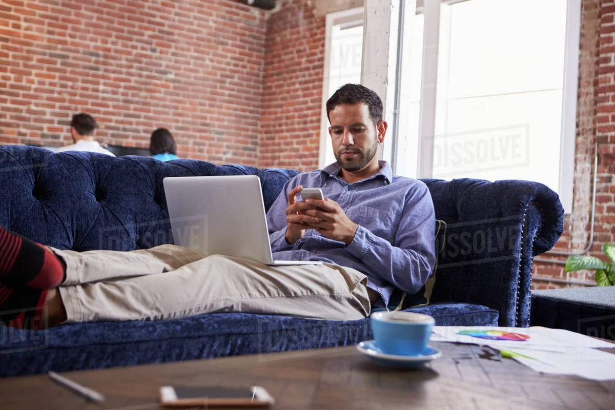 Businessman working on sofa in modern creative office - Royalty-free ...