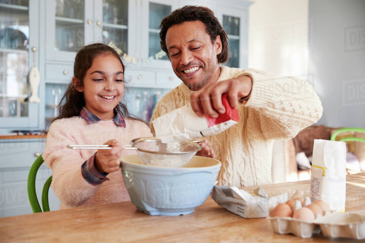 Father and daughter baking cookies at home together - Royalty-free ...