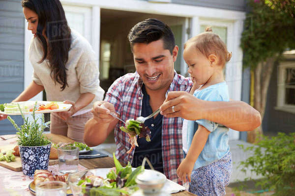 Family at home eating outdoor meal in garden together - Royalty-free ...