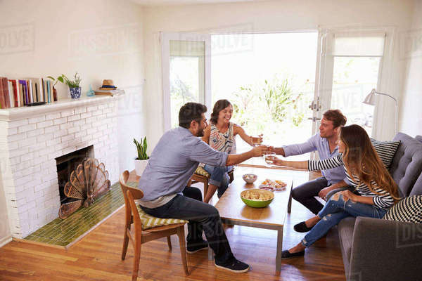 Couple entertaining friends at home - Royalty-free Stock Photo | Dissolve