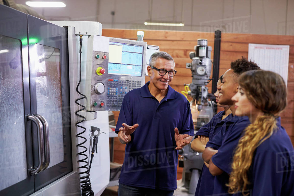 Engineer training apprentices on CNC machine - Royalty-free Stock Photo ...