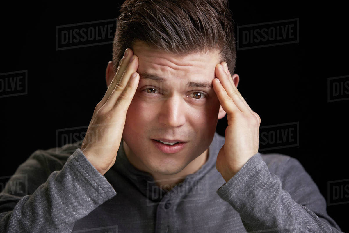 Portrait of a worried young white man holding head - Royalty-free Stock ...