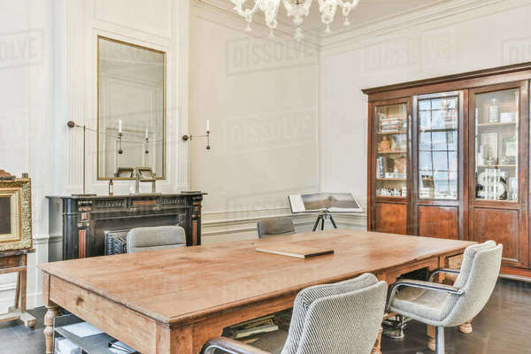 Classic interior of mansion work room with wooden table and cupboard ...