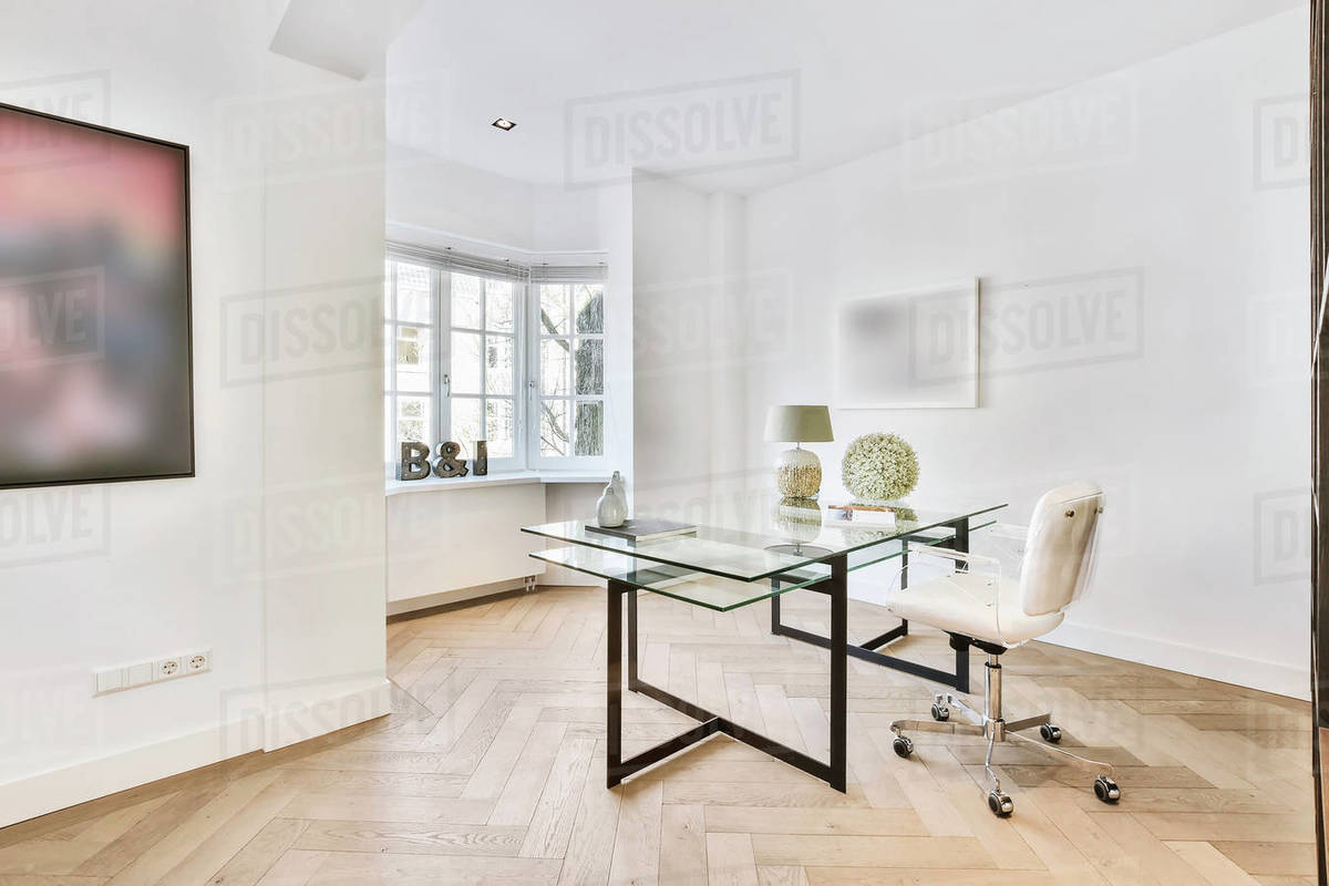 Spacious study room with futuristic glass table and armchair against ...