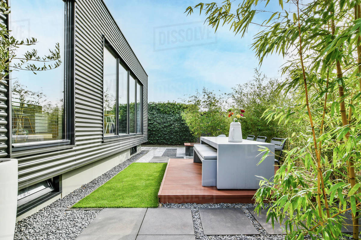 Beautiful backyard terrace full of furniture and decorative plants ...