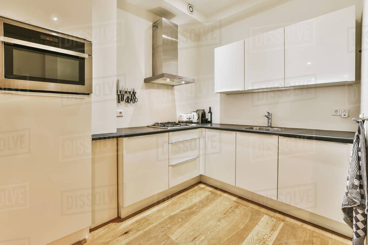 Modern home kitchen corner interior design with white cupboards and ...