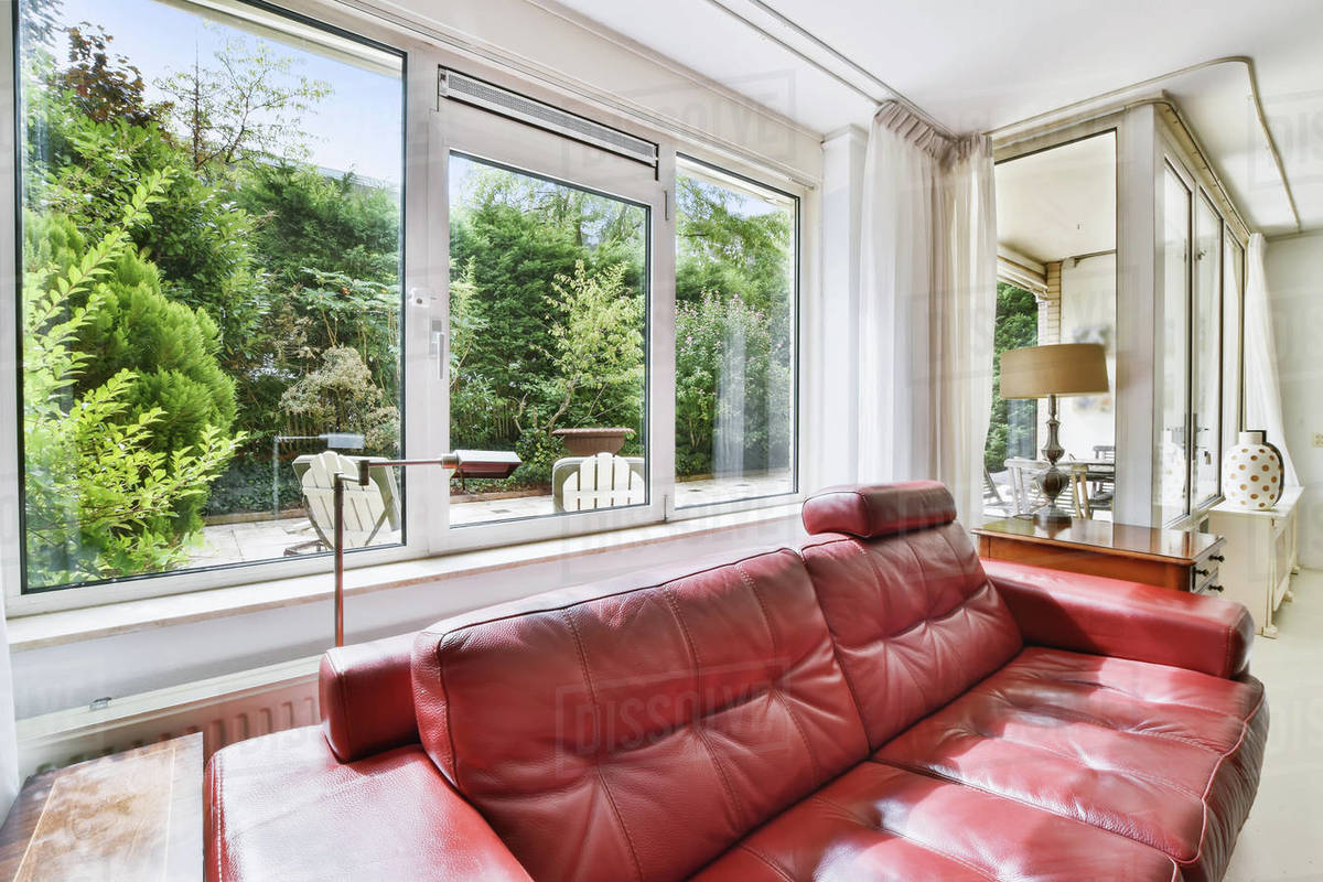 Stylish living room with big red sofa - Royalty-free Stock Photo | Dissolve