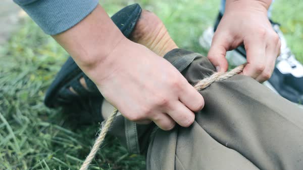 Close-up of a man's legs being tied with a rope. Abduction of husband ...