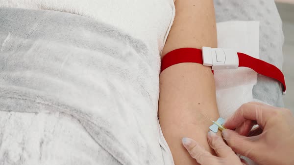 The nurse pierces the patient's arm with a needle to take a blood test ...
