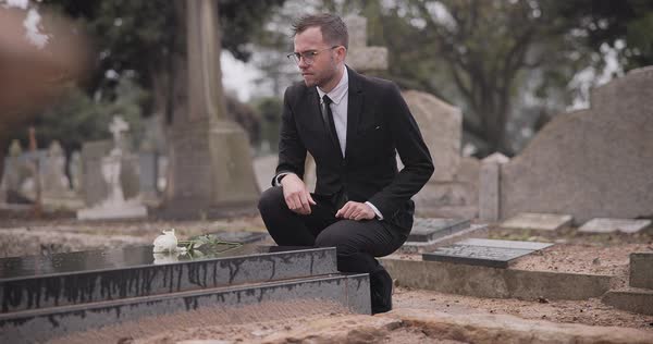 Funeral, cemetery and man with flower at tombstone for remembrance ...