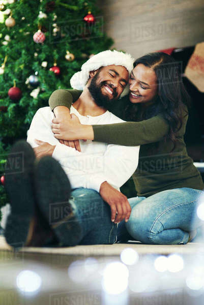 Couple, love and bonding hug in christmas house or home living room in ...