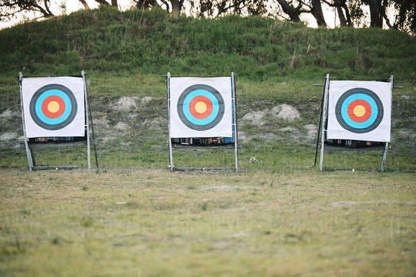 Bullseye target board, outdoor and field at shooting range for weapon ...