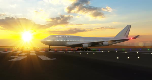 Passenger airplane taxiing into line up position against scenic sunset ...